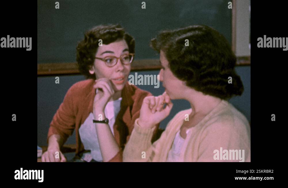 1950s: Clapperboard. Two girls sit in classroom and gossip Stock Video Footage - Alamy