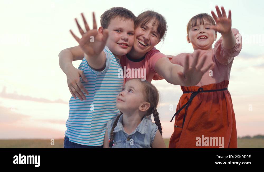 Mom, Children happily wave their hands, look at camera. Happy child ...