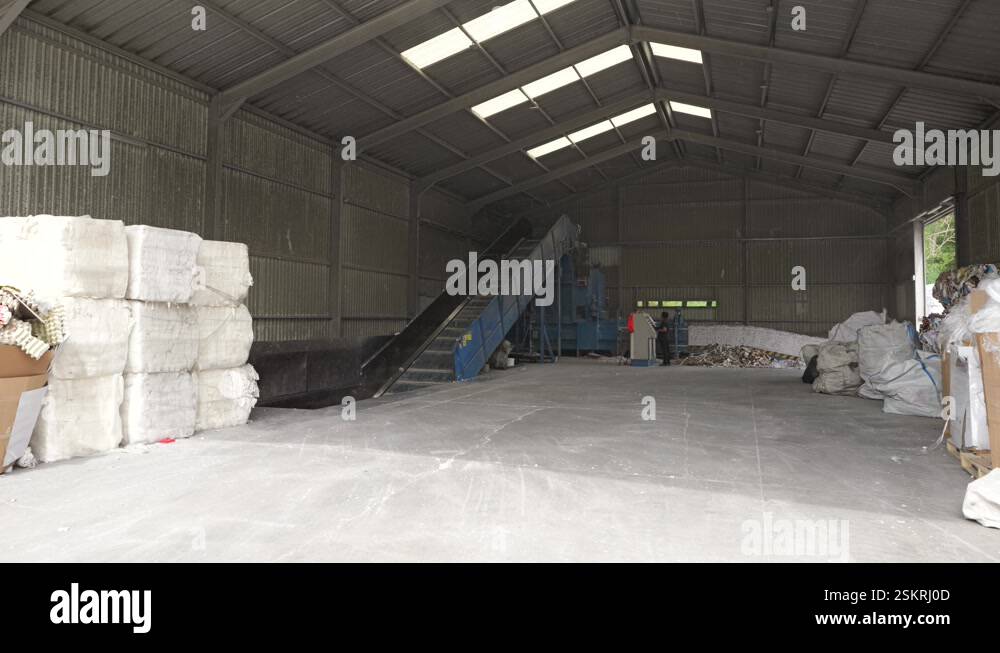 Dolly forward into paper recycling center facility with conveyor belt ...