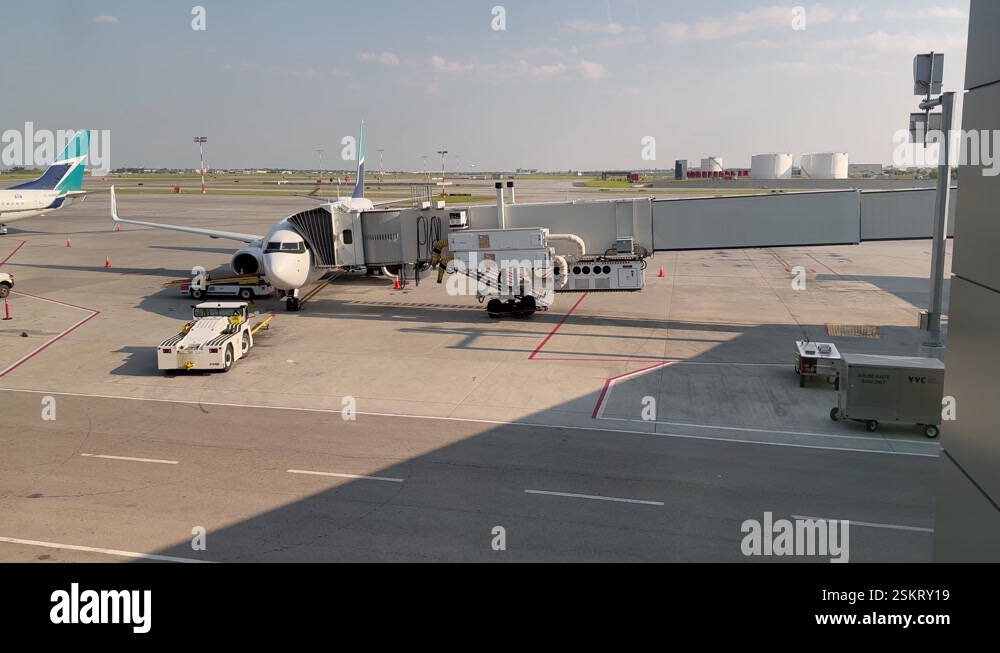 Parked WestJet Airplane Connected to Loading Bridge at Airport Gate at ...