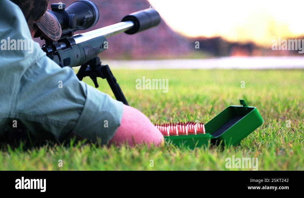 Man lying prone shoots target practice with high calibre rifle and ...
