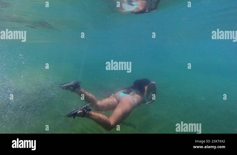 Beautiful woman in bikini swims slo mo underwater in teal river Stock Video Footage - Alamy