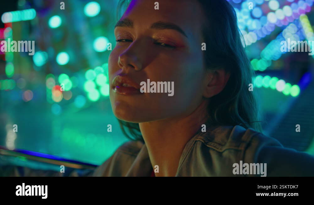 Attractive woman posing neon funfair carousel closeup. Gorgeous trendy ...