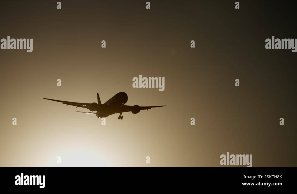 A passenger plane coming in for landing is flying with its landing gear ...