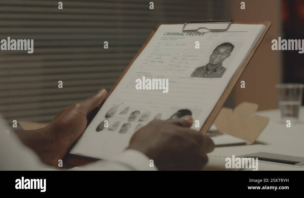 Police Detective Reading Criminal Profile in Interrogation Room Stock ...