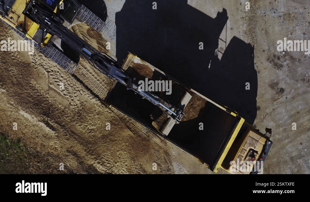 Excavator loads soil with buckets into body of dump truck Stock Video ...