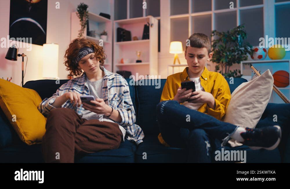 Two teenage boys using their smartphones and ignoring real life ...