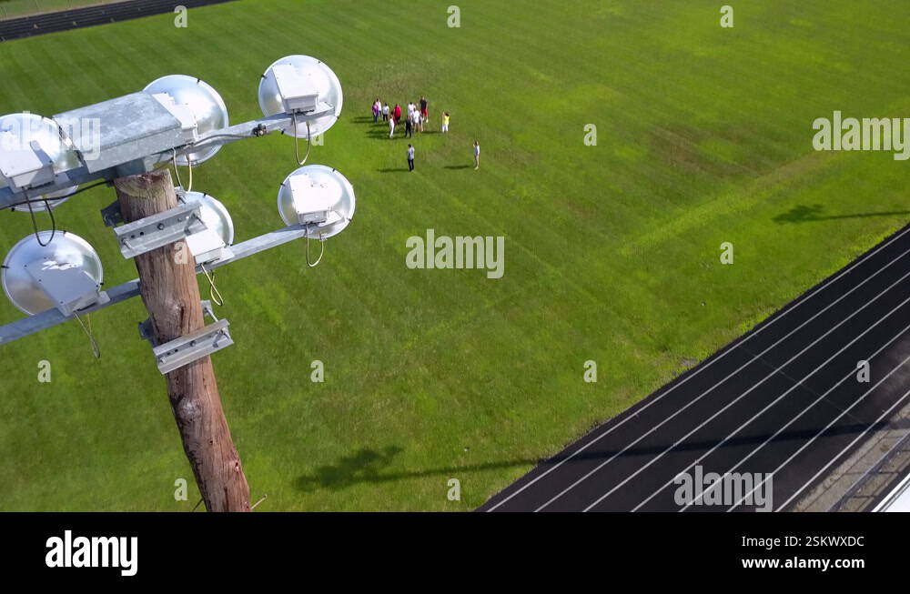 Aerial Tilt Up Shot Of People In Sports Field Against Sky On Sunny Day ...