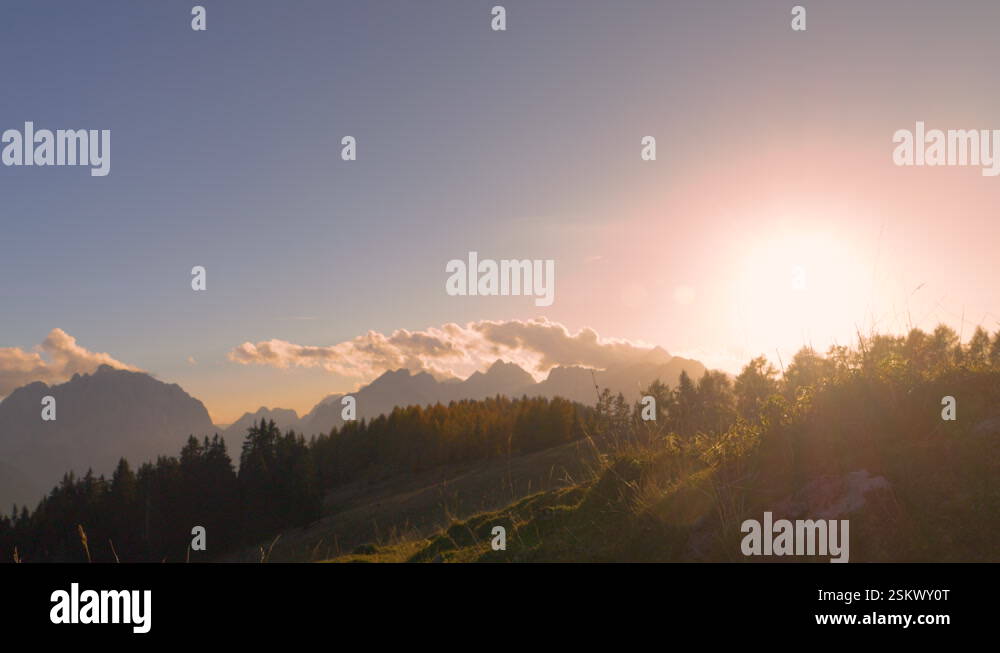 CLOSE UP, LENS FLARE Sporty man and his dog jump over rising sun and ...