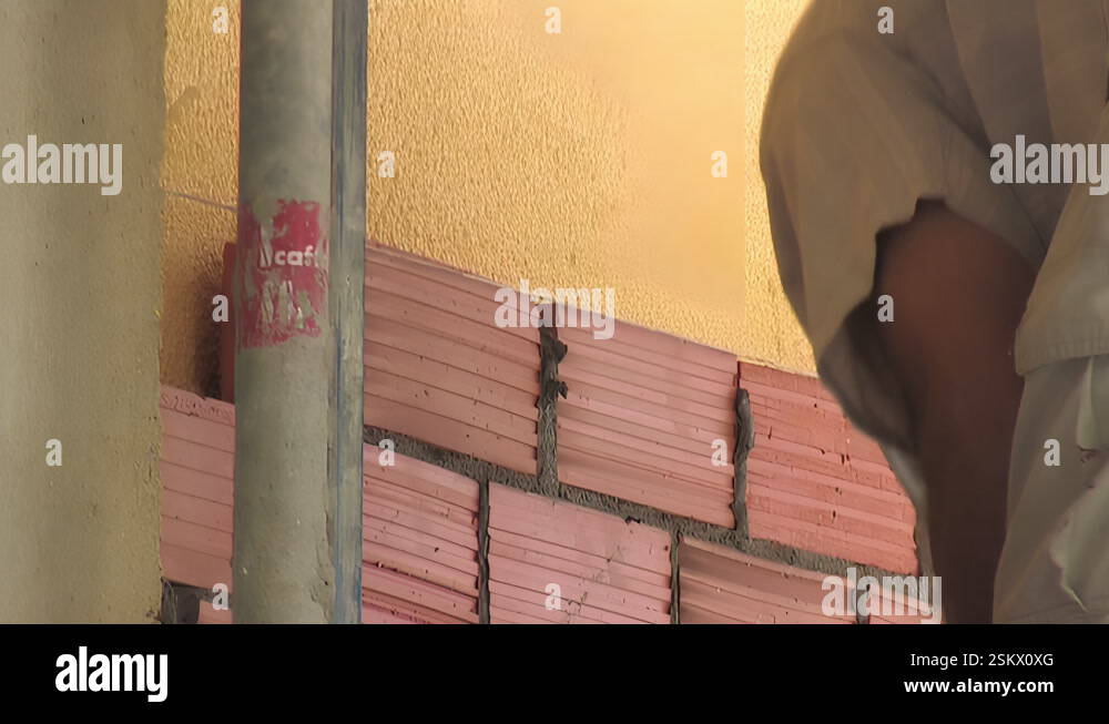 Bricklayer on a scaffold putting mortar and brick making a wall Stock ...