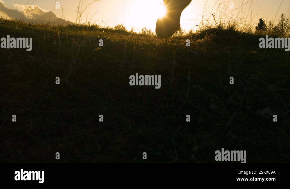 LENS FLARE: Lady reaches top of a scenic hill after running and jumps ...