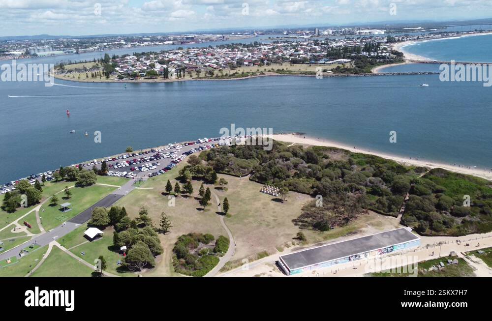 Drone flying over a park and carpark towards a river bend and a large ...