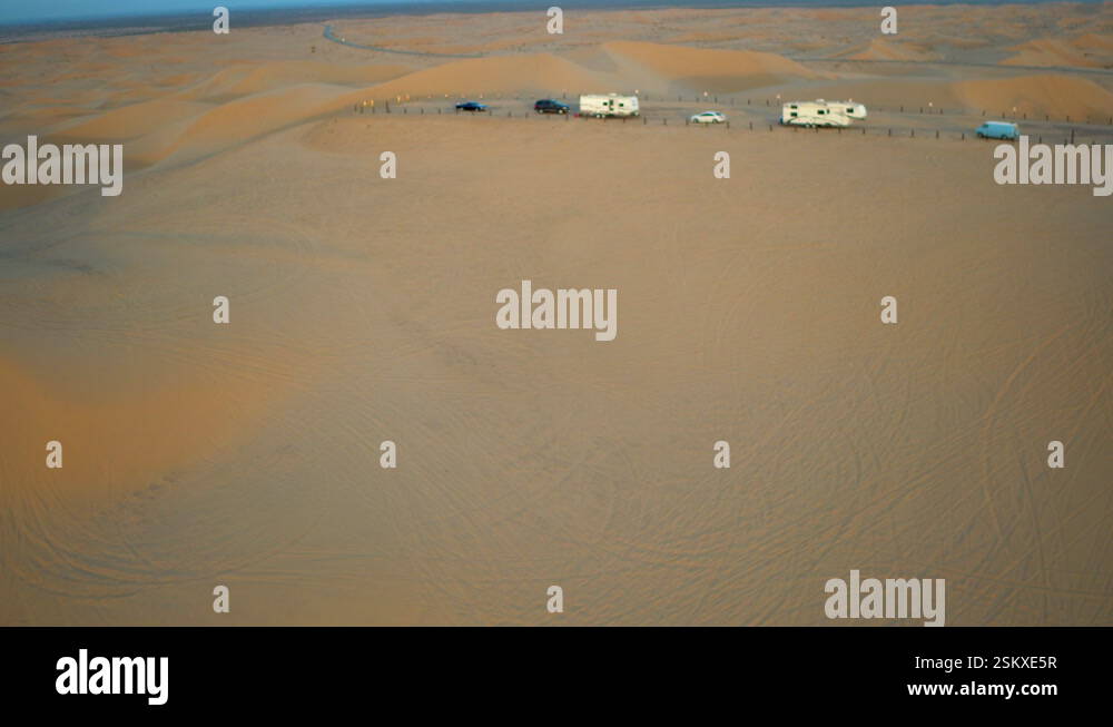 Aerial Forward Shot Of Vehicles On Road In Desert Landscape At Sunset ...