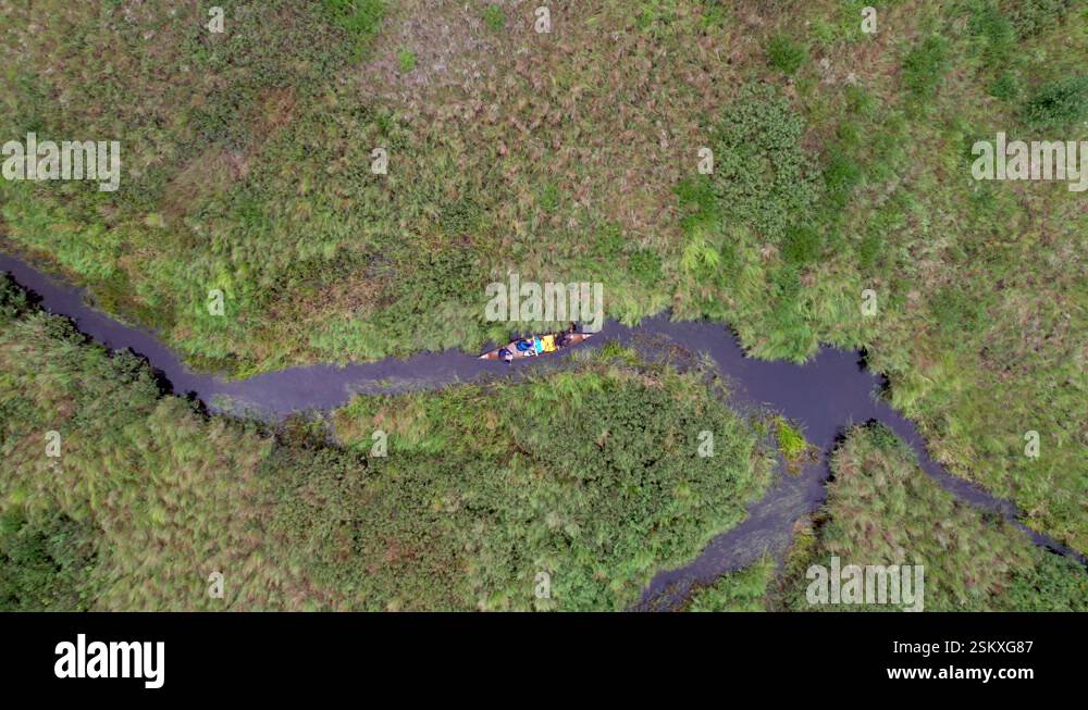 Overhead of a canoe traversing extremely narrow river, camping ...