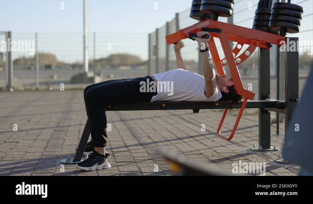 Fit and Muscular Young Man Focuses on his Arm Muscle Workout Outside ...