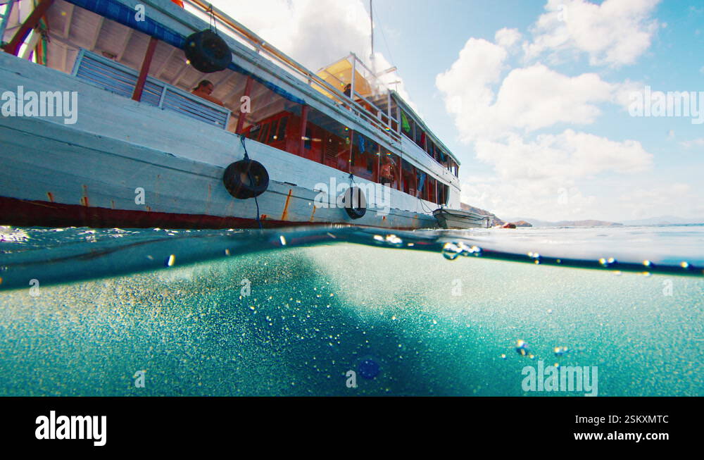 Splitted footage above and underwater of the boat in the tropical sea ...