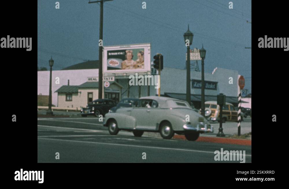 1950s: Intersection. Driver signals turn with arm. Hand holds shooting ...