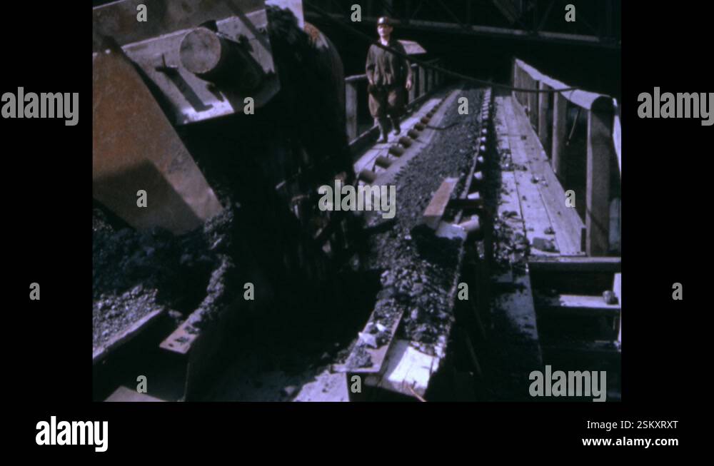 1960s: Coal pours onto conveyor belt in mine. Rail cars full of coal ...
