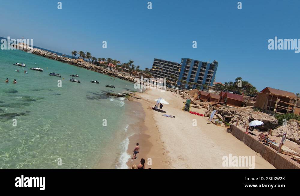 Fpv flyover sandy beach with many Tourist and resort hotel at Batroun ...