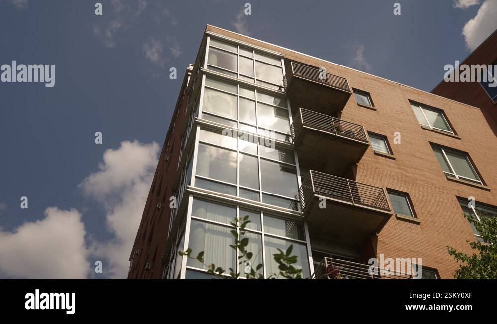 upwards orbiting shot of an apartment or condo building with the sun ...
