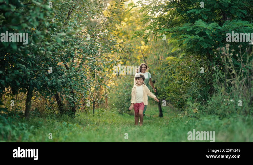 Mom, kids playing running on plot in country house. Ecological life ...