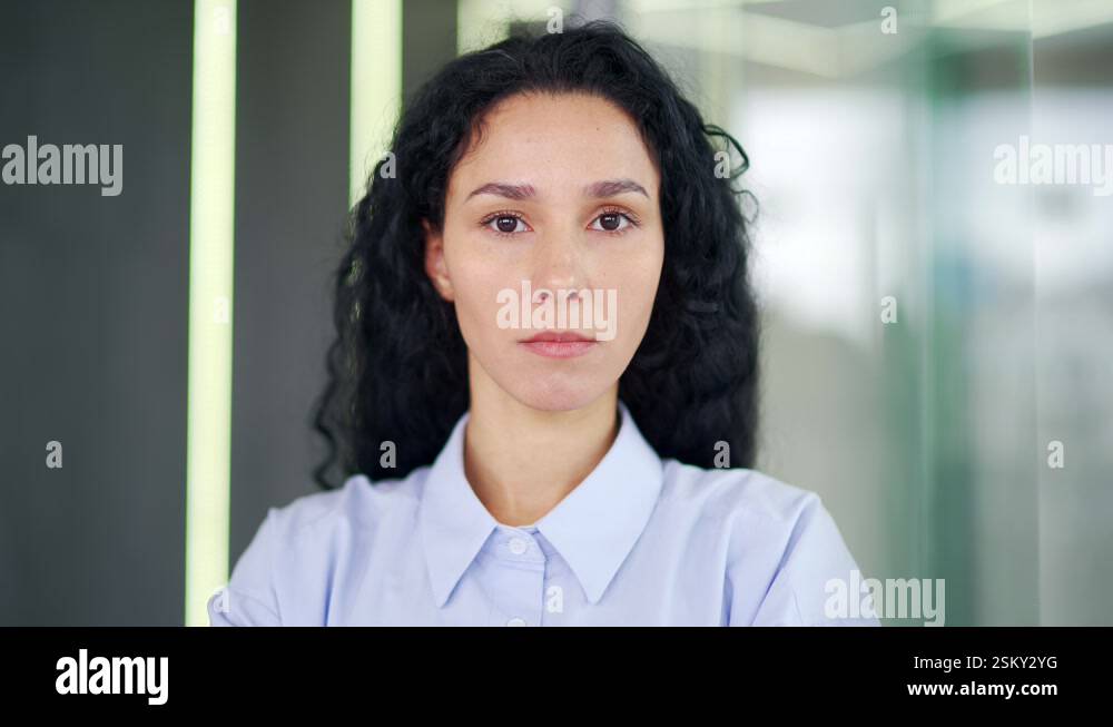 Close up. Portrait of a young confident female employee standing in a ...