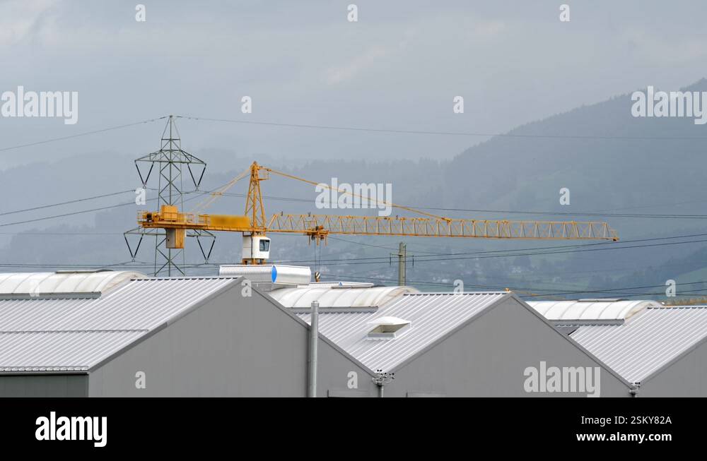 Yellow Construction Crane With Electricity Pylon In Background At Stock ...