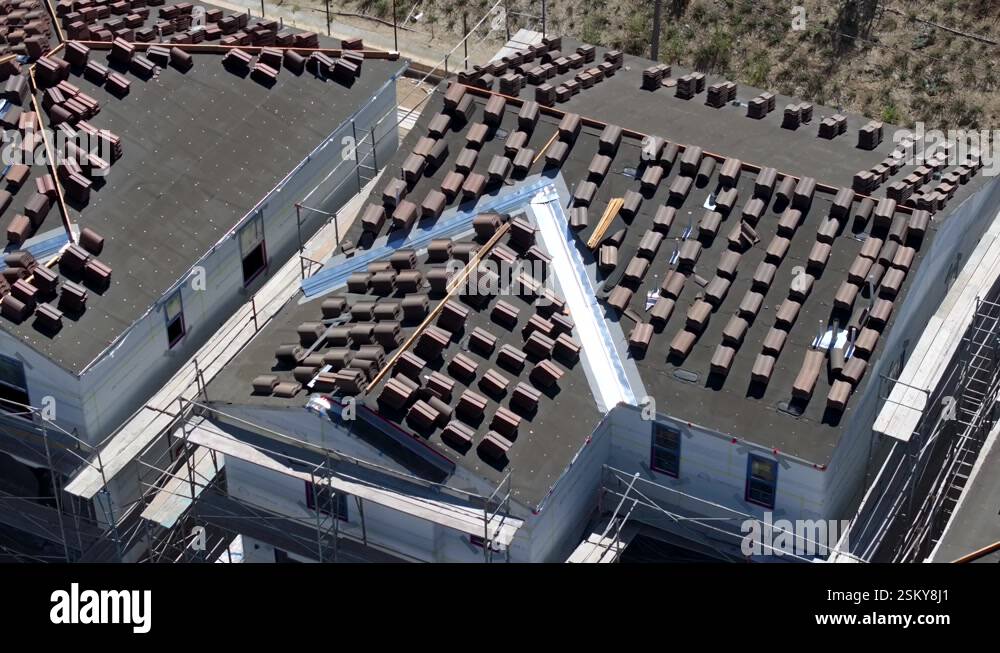 Roofing tiles on new housing construction projects - rising aerial tilt ...