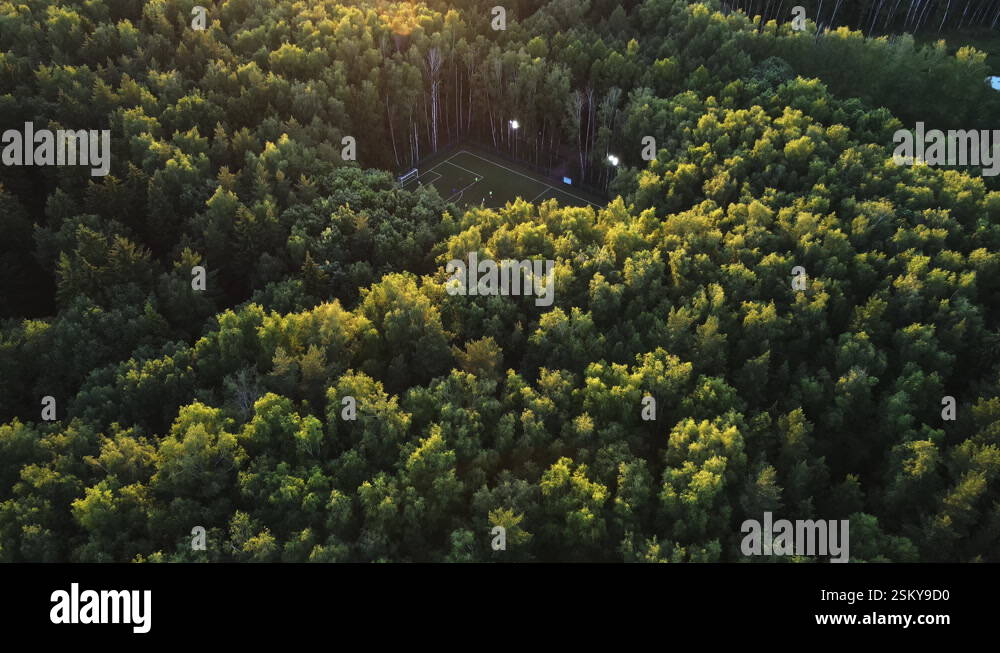 Aerial tilt shot over a soccer game at a football field in middle sunny ...