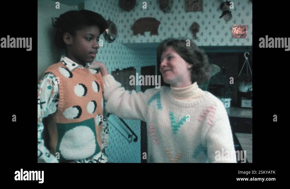 1980s: Two teen girls in kitchen. One opens the fridge and opens a beer ...
