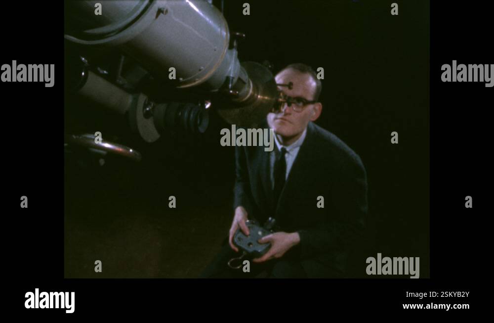 1960s: Man looks through telescope and uses remote control Stock Video ...