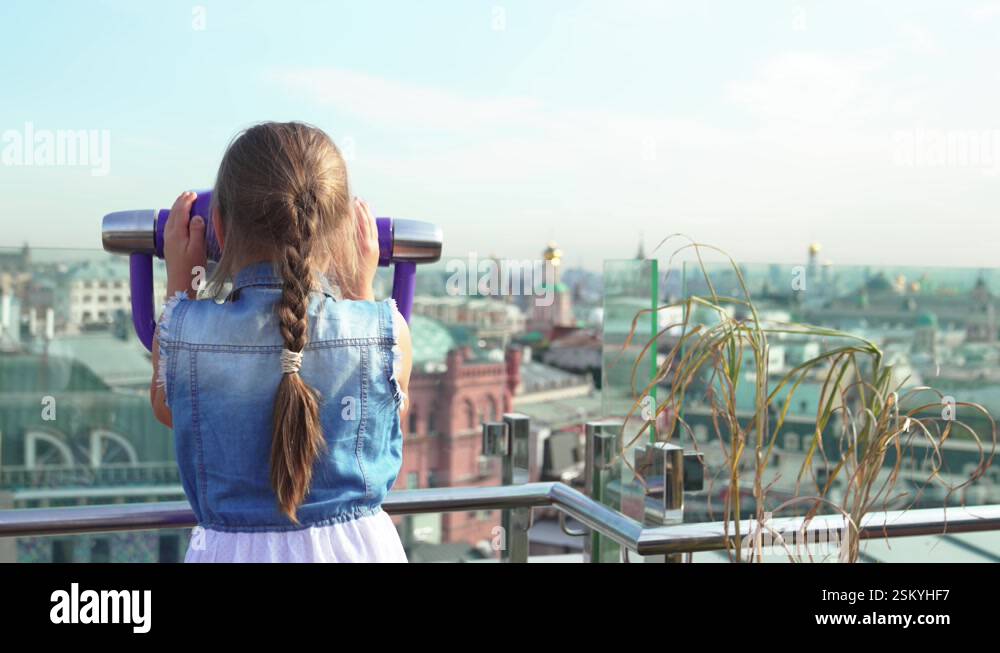 a teenage girl looks into the Binoscope from the observation deck at a ...