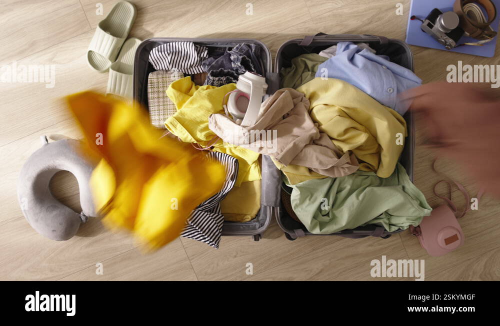 Clothes fall from above into open suitcase. Throwing clothes into ...
