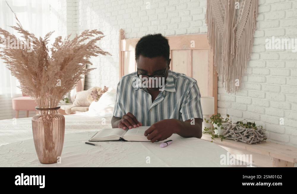African black man reading bible. Fingers going line by line. Reading ...