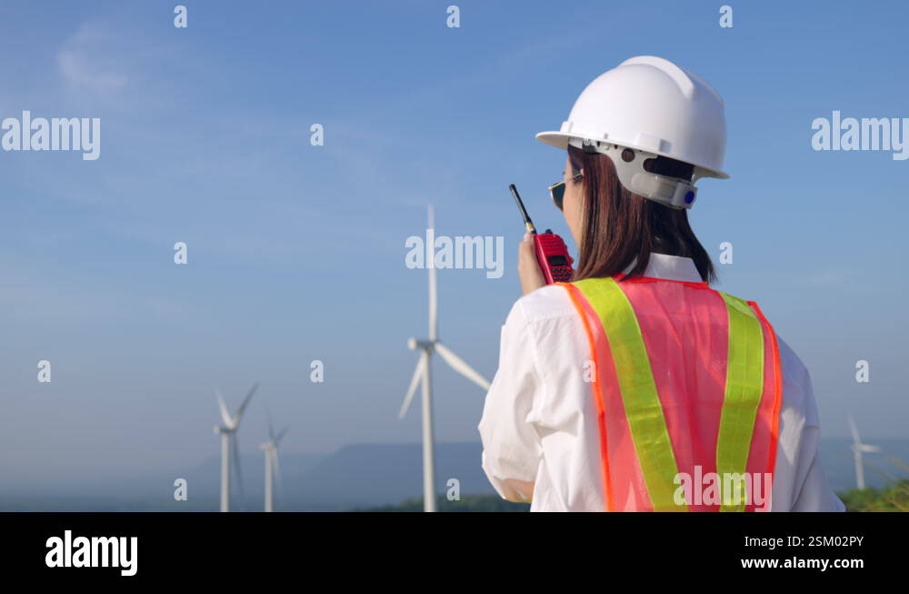 Back view of woman engineer talking to her team with radio ...