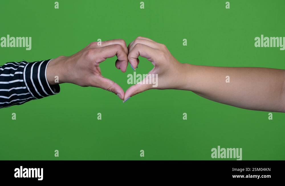 Boy and girl making a heart shape using hands - green screen, love and ...