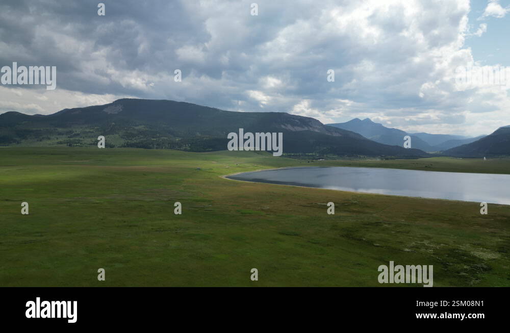 Valley Lake with Ominous Mountains and Striking Clouds Stock Video ...