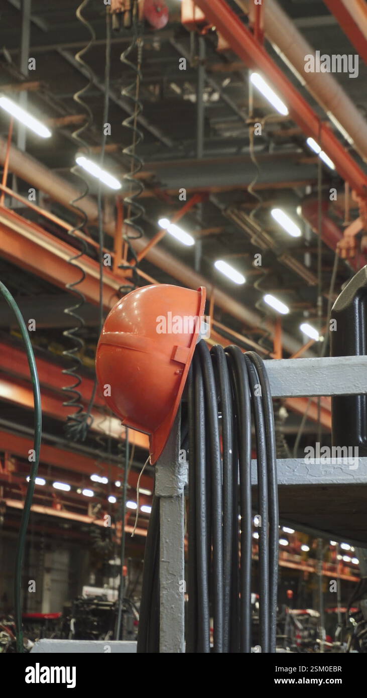 Plastic safety helmet hangs on corner of rack on plant automobile ...