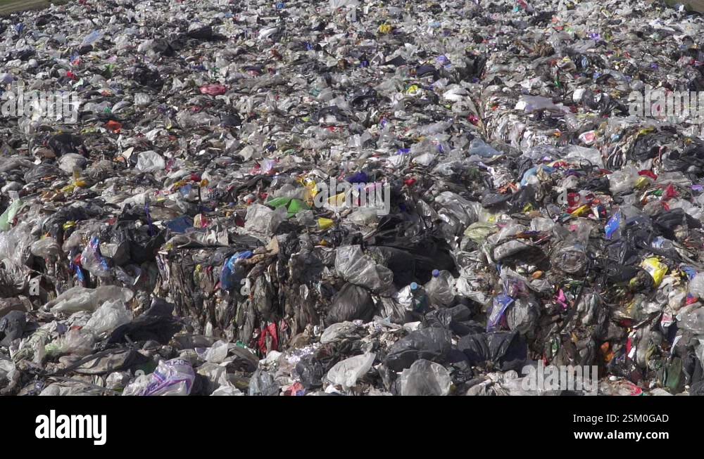 Zoom in on plastic waste in a dumping ground. Slow motion, handheld ...