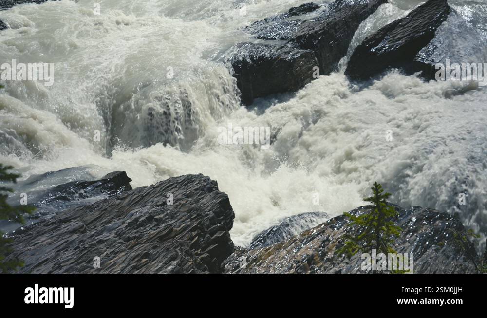 A small water fall in Yoho National Park, water flowing over rocks in ...