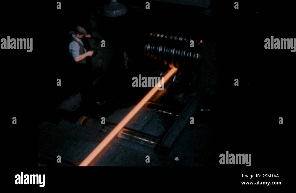 1960s: Length of molten metal in rod shape rolls out of furnace Stock ...