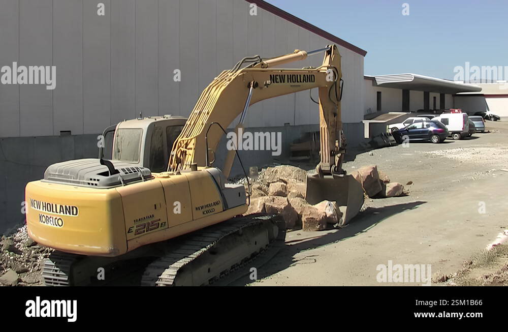 Excavator shovel loading and unloading stones in the construction of a ...