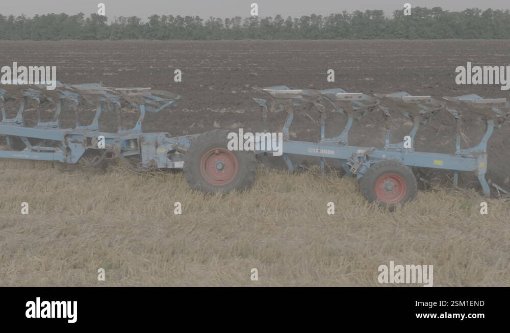 Hi productive reverse plow moving behind a tractor in an field. Plowing ...