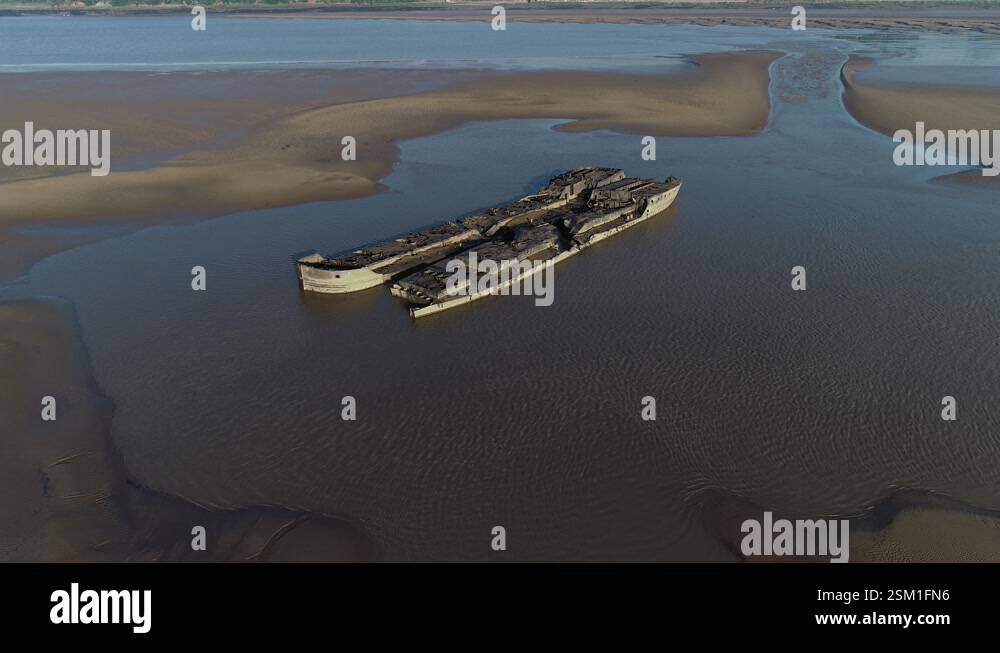 Two wrecked freighters in estuary mud. Drone view. Rusting ships side ...