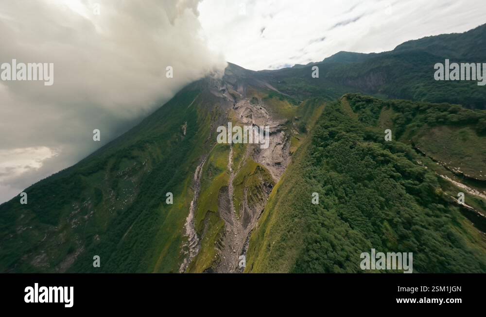 Aerial epic view erupting volcano rocky black lava on slope white smoke ...