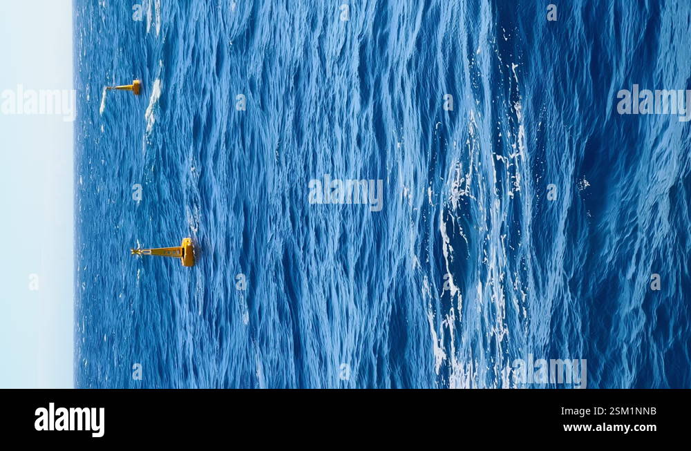 Vertical footage of yellow marks on the sea surface on a clear sunny ...