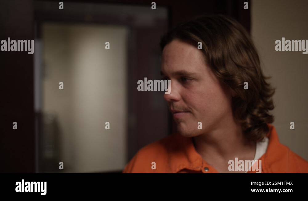 Prison inmate locked up inside his cell. Unhappy, brooding, convict ...