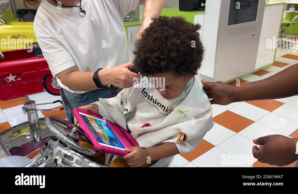 Three-year-old exotic black kid getting a haircut at a children’s salon ...