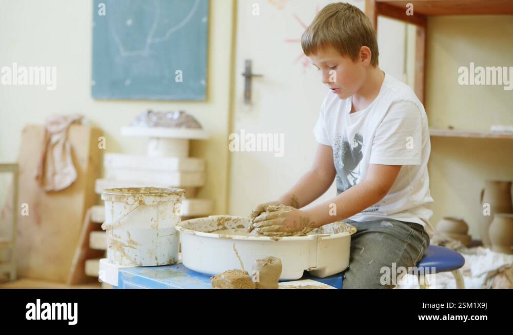 A boy in a pottery workshop, working on a potter's wheel Stock Video ...