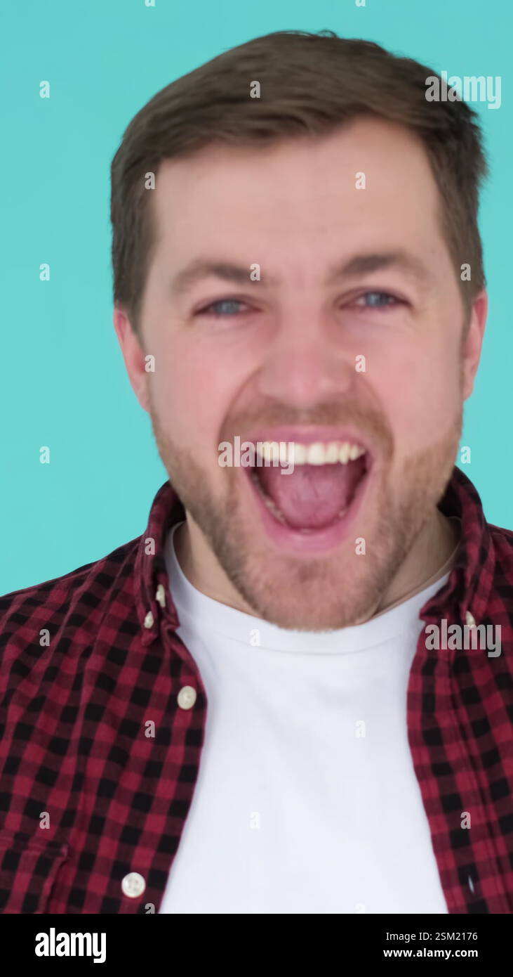 Handsome man shows joy on studio background. A guy of 30 years old with ...